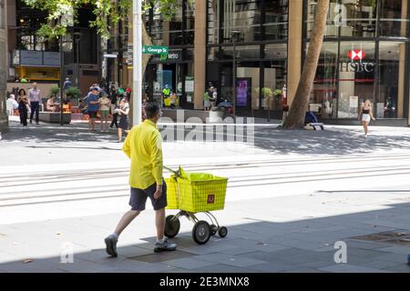 Australia Post employee postman with mail delivery trolley delivering ...