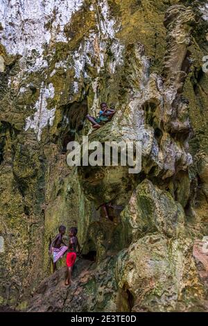 Locals in a brackish water cave on Panasia Island, Papua New Guinea. At ...