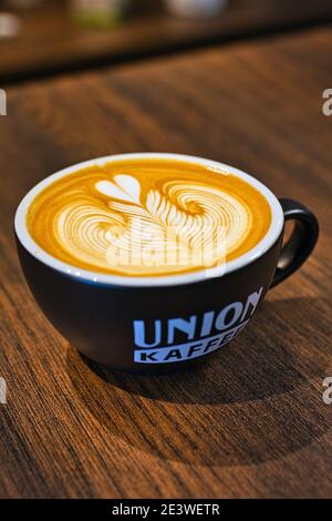 latte art on wooden background. Beautiful foam, ceramic cup, stylish ...