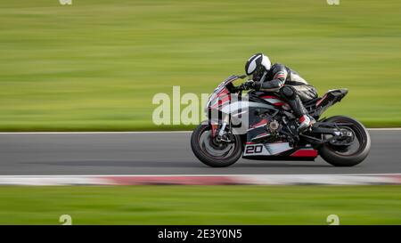 A panning shot of a racing bike cornering on a track Stock Photo - Alamy