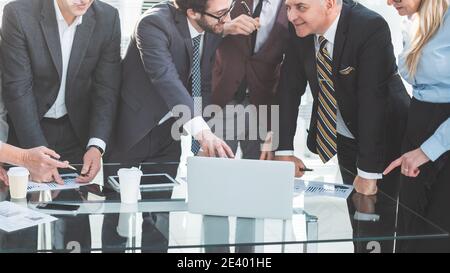 group of employees enthusiastically looking at the laptop screen Stock ...