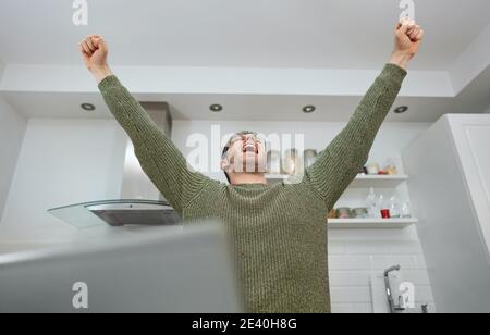 Excited man with laptop. Online gaming concept Stock Photo - Alamy
