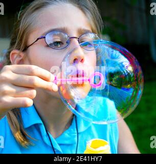Cheerful girl blowing soap bubbles Stock Photo - Alamy