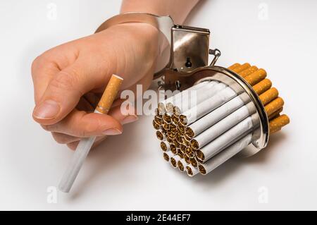 Female hand with handcuffs and cigarettes on white background - concept ...
