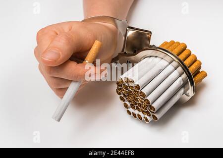Female hand with handcuffs and cigarettes on white background - concept ...