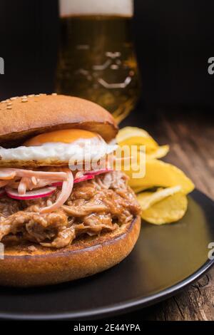 A closeup shot of a tasty hamburger served on a plate with cherry ...