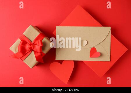 Envelopes, gift and hearts on red background with space for text ...