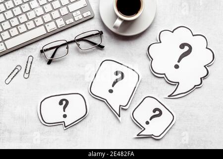 Question marks on office dest - FAQ concept. Top view Stock Photo - Alamy