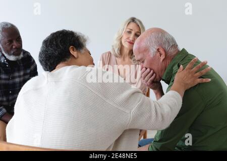 Diverse group of seniors talking during a group therapy session at home ...