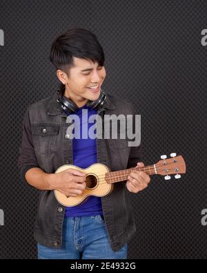Guitar ukulele in man hand against cloudy sky, nature blurred ...