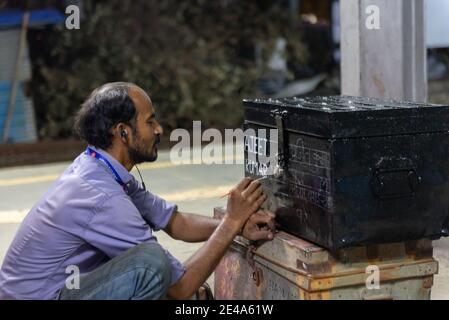 Railway station staff writing name of newly joined loco pilot on a line ...