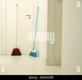 Closed wooden door and red broom outside a traditional brick house ...