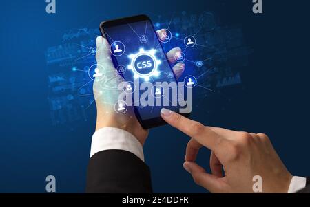 Female hand holding smartphone with CSS abbreviation, modern technology ...