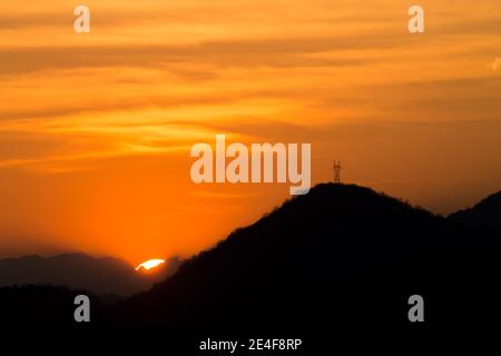 Outline of mountains at sunset with electric pylon. Mountain landscape ...