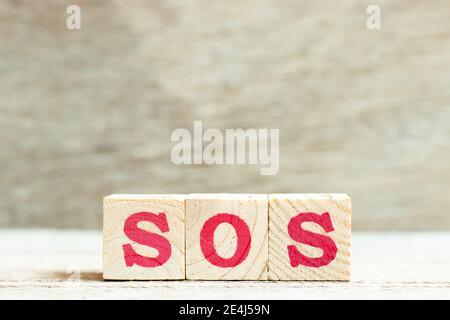 Wood letter in word SOS (abbreviation of save our soul/ship or sibling ...
