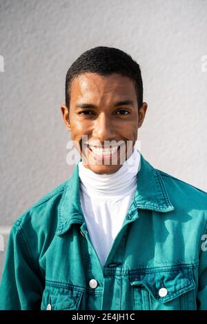Portrait of smiling man standing by gray wall with arms crossed Stock ...