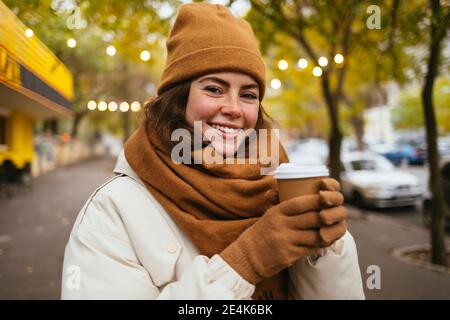 Young woman in cap with disposable electronic cigarette on pink ...