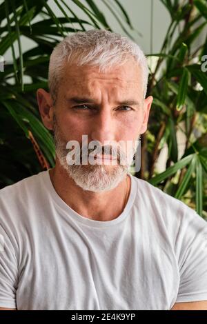 Handsome man with a beard and hair in winter jacket walking in a snowy ...