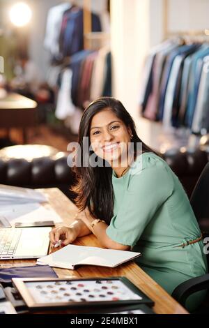 Portrait of happy smiling Indian seamstress working at her home office ...