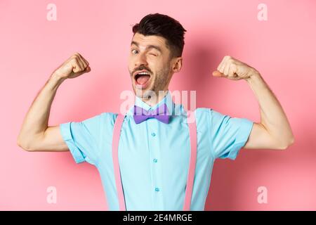 Strong and funny guy with french moustache, flexing biceps and winking ...
