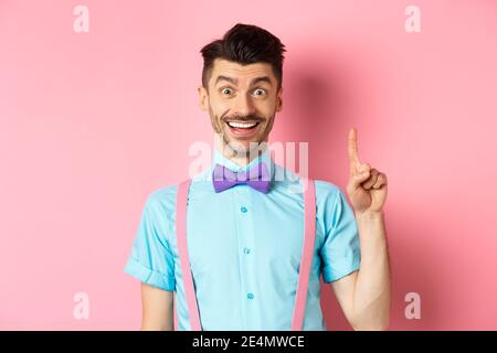 Thoughtful guy suggesting solution, raising finger in eureka sign and ...