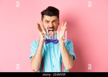 Angry man screaming like crazy, shaking hands and stare furious at ...