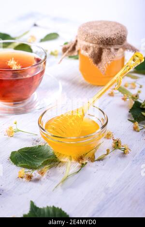 Honey and honey dipper on green and white checked cloth in flat lay ...