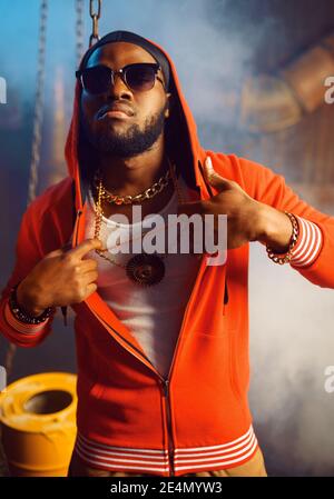 Rapper in red hoodie and sunglasses in studio with cool underground ...