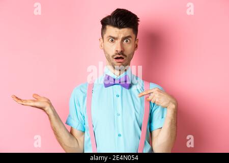 Confused funny guy with moustache pointing fingers up at something ...