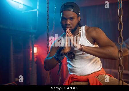Stylish rapper poses near the chains in studio with cool underground ...