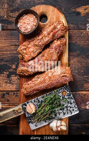 Raw Marinated skirt steaks in bbq sauce on a wooden cutting board with ...