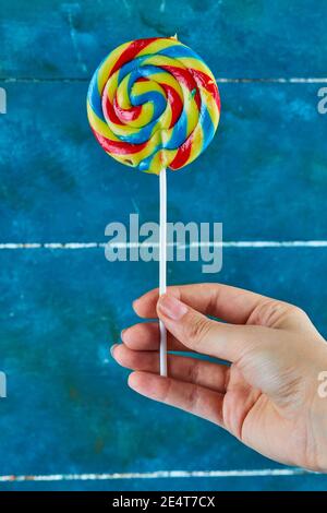Hand with sweet lollipop on color background Stock Photo - Alamy