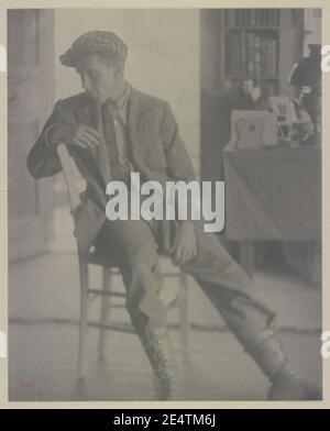 Maynard White in suit, wearing boots and cap, seated Stock Photo - Alamy