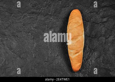 Fresh wheaten baton bread on dark background. Top view. Copy space ...