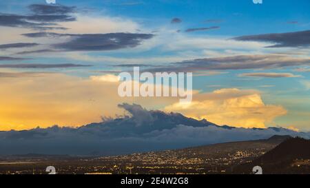 Sun rising behind the volcanoes, with some clouds and a blue sky Stock ...