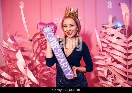 Pleased woman with a fake crown holding a champagne flute Stock Photo ...