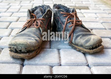 Old torn boots of leather with a hole Stock Photo - Alamy