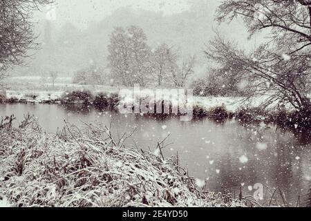 Snow falling over the River Wey in Godalming, Surrey, UK Stock Photo ...