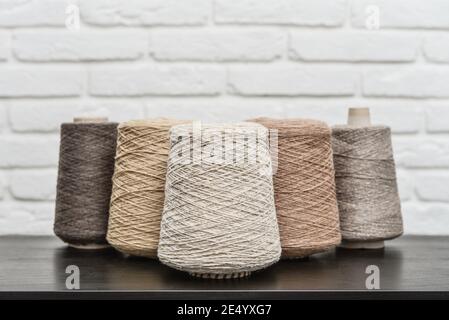 Set of colored yarn for knitting on cone on light background, with copy ...