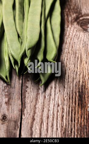 Piattoni green beans isolated on wooden background. Taccole. Top view ...