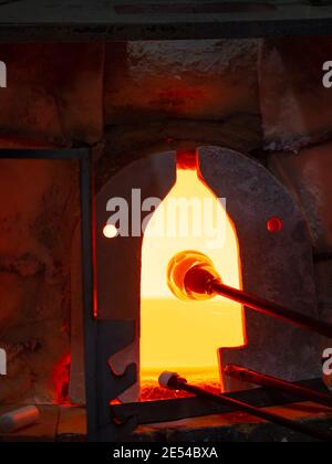 Shining glass blowing furnace at work. Gas kiln in glass design studio ...