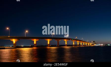 Illuminated bridge going over the sea at night Stock Photo - Alamy