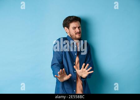 Image of man cringe and look at something disgusting, step back from ...