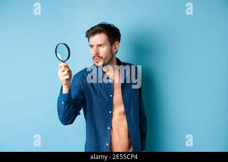 Serious man investigating or searching for something, look through ...