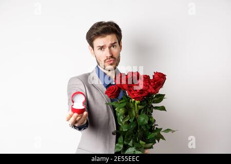 Handsome boyfriend in suit asking to marry him, standing with red ...