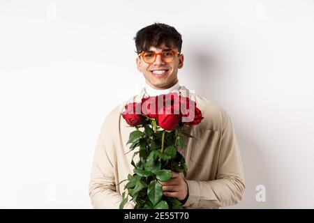 Handsome hipster guy waiting for his lover with bouquet of roses. Young ...