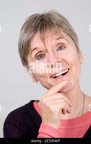 Senior Woman with Finger on Chin Stock Photo - Alamy