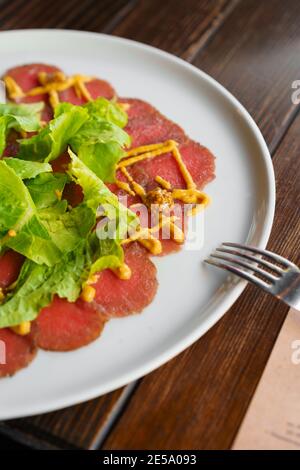 Carpaccio dish of thinly sliced pieces (slices) raw beef tenderloin ...