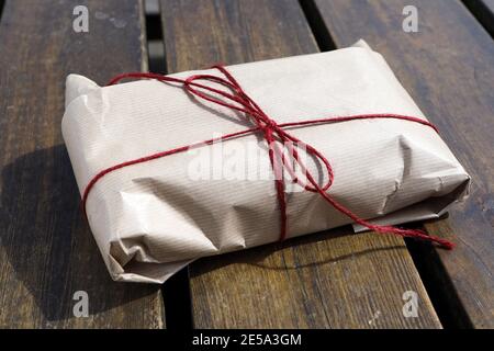 A parcel wrapped in brown paper and tied with rough twine and two blank ...