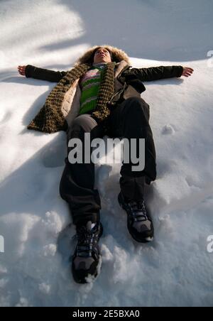 Young woman resting in snow Stock Photo - Alamy